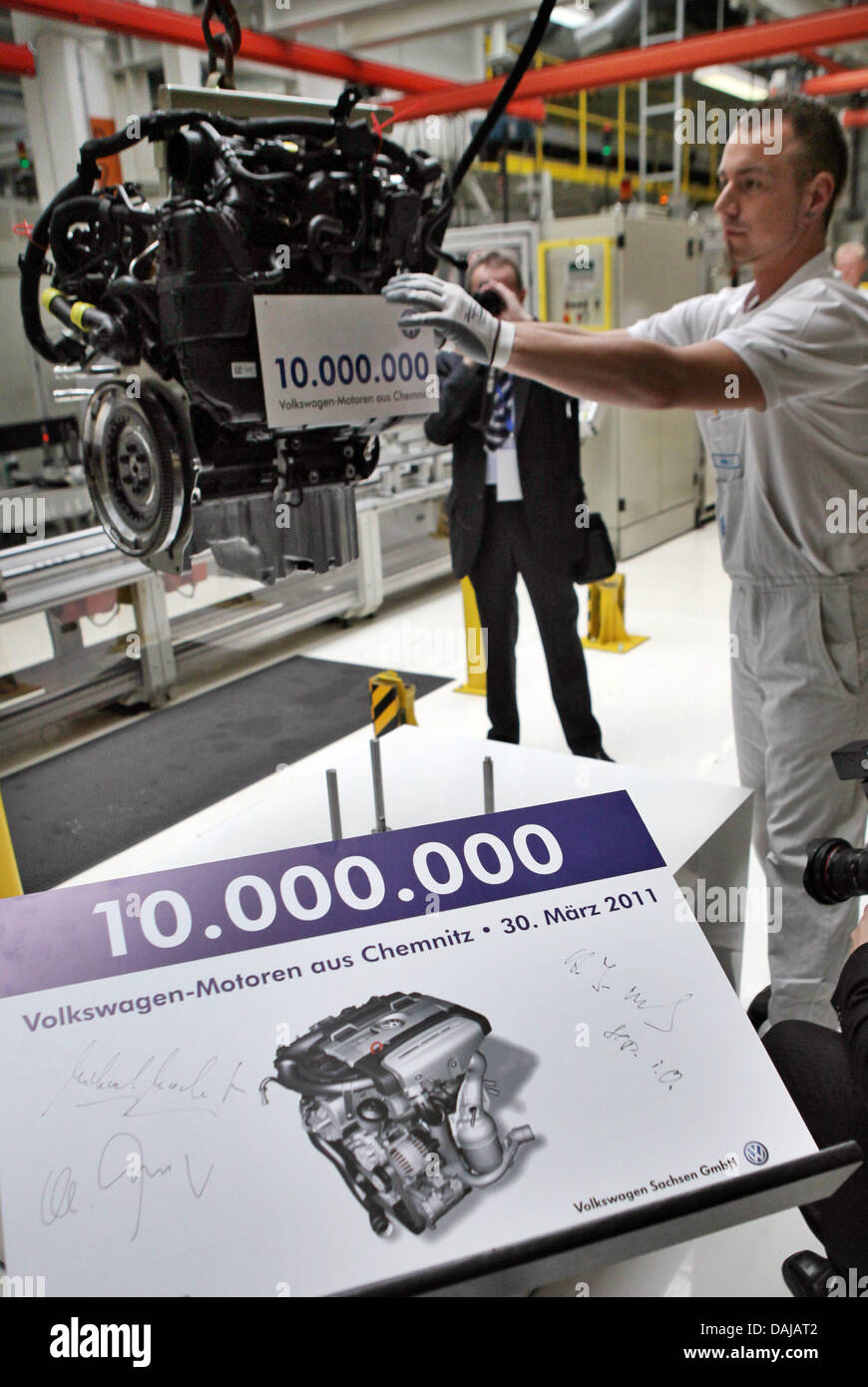An employee of the engine factory lifts Volkswagen's ten millionth ...
