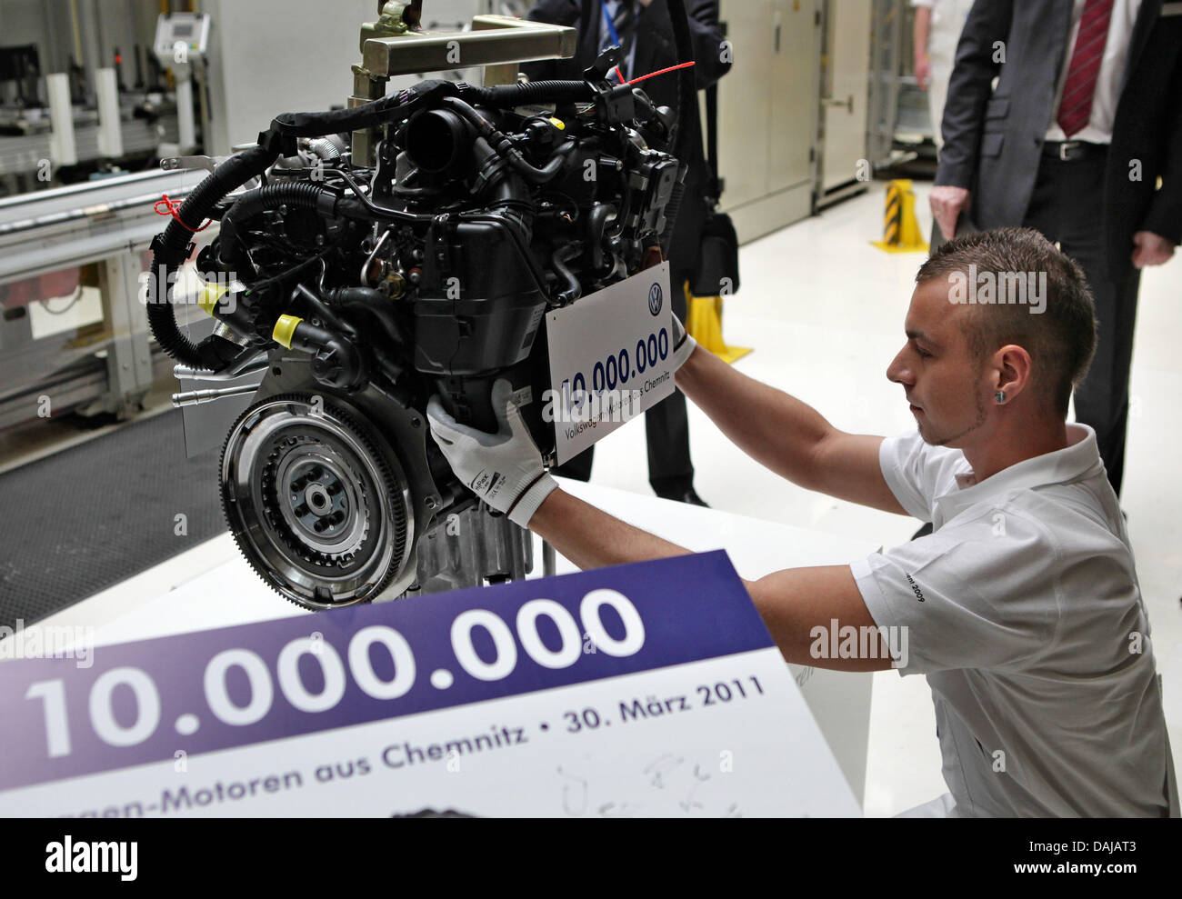 An employee of the engine factory lifts Volkswagen's ten millionth ...