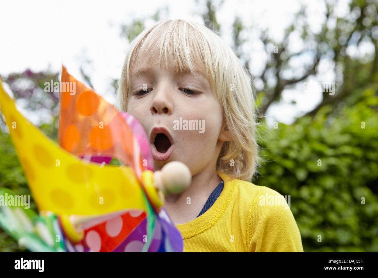 Germany, Cologne, Boy blowing paper windmill Stock Photo - Alamy