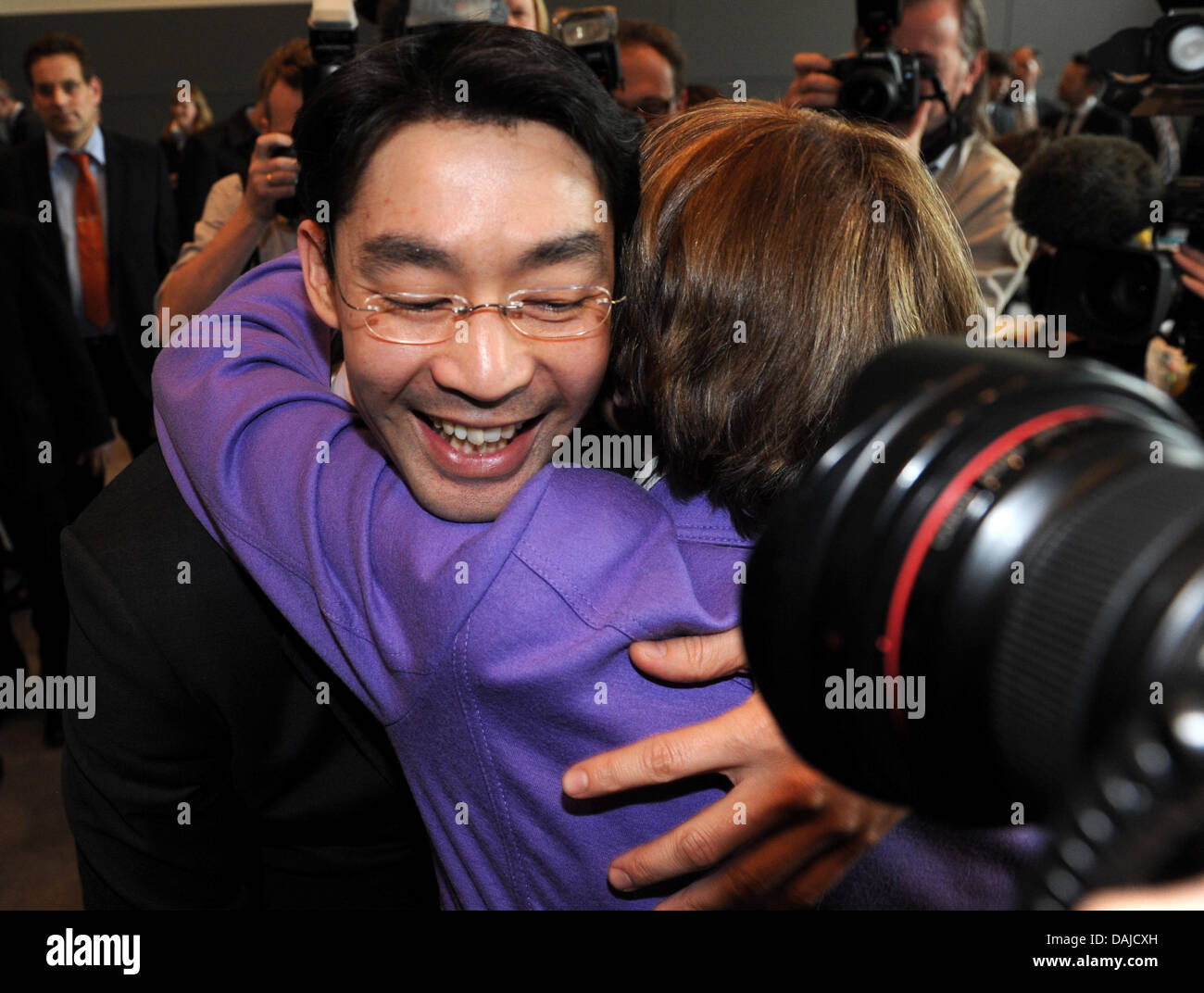 Health Minister of Germany Philipp Roesler hugs a woman at the joined ...