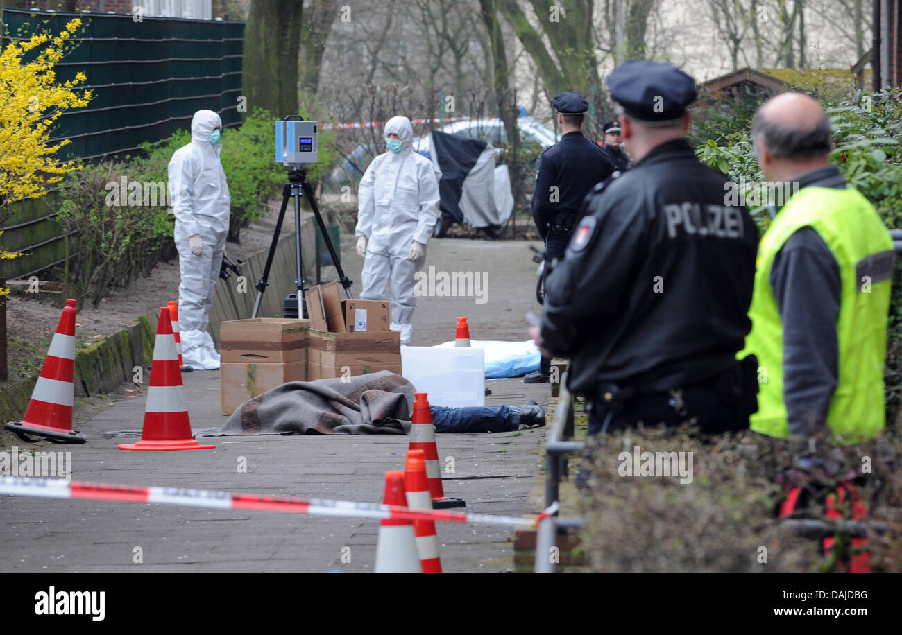 Police officers and forensics secure evidence at a crime scene of a ...