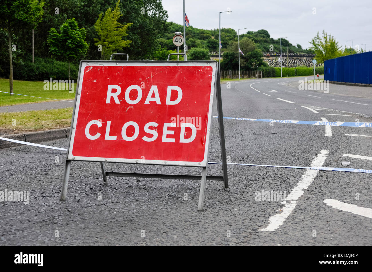 A red temporary "Road Closed" sign with police tape Stock Photo - Alamy