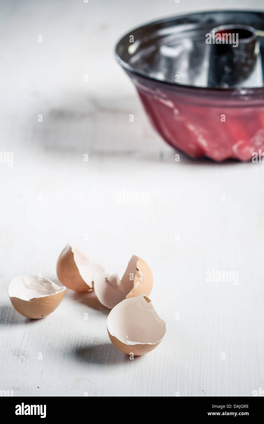 Eggshells and red cake tin, close up Stock Photo - Alamy