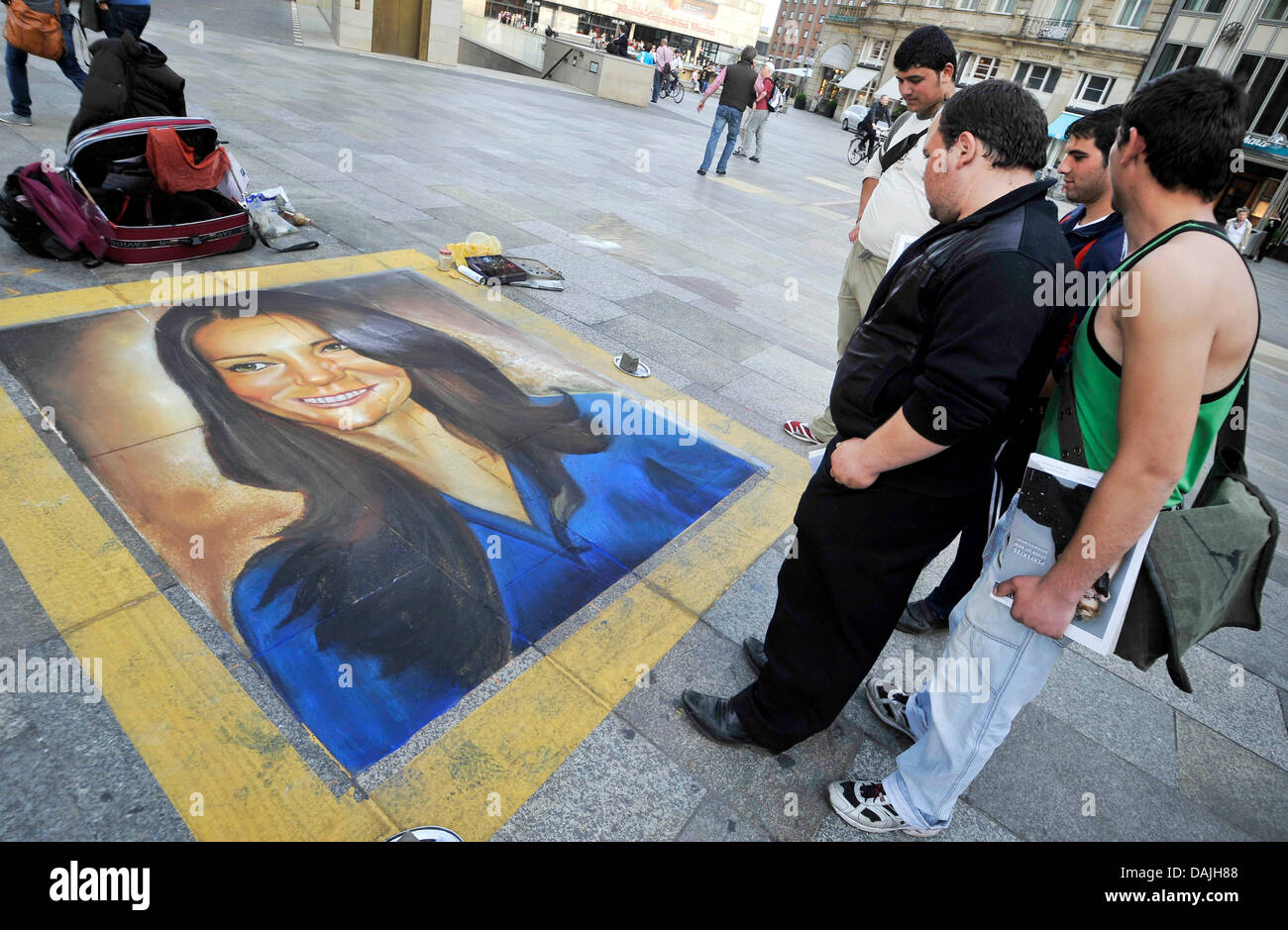 Tourists look at a chalk portrait of Kate Middleton, the future wife of ...
