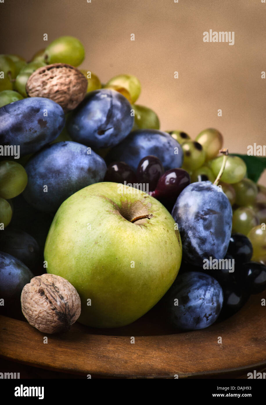 Autumn fruit in wooden plate Stock Photo - Alamy