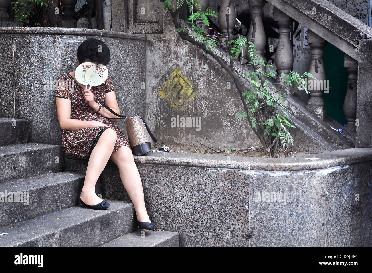 Chinese woman resting on the steps of Pottinger Street, Central ...
