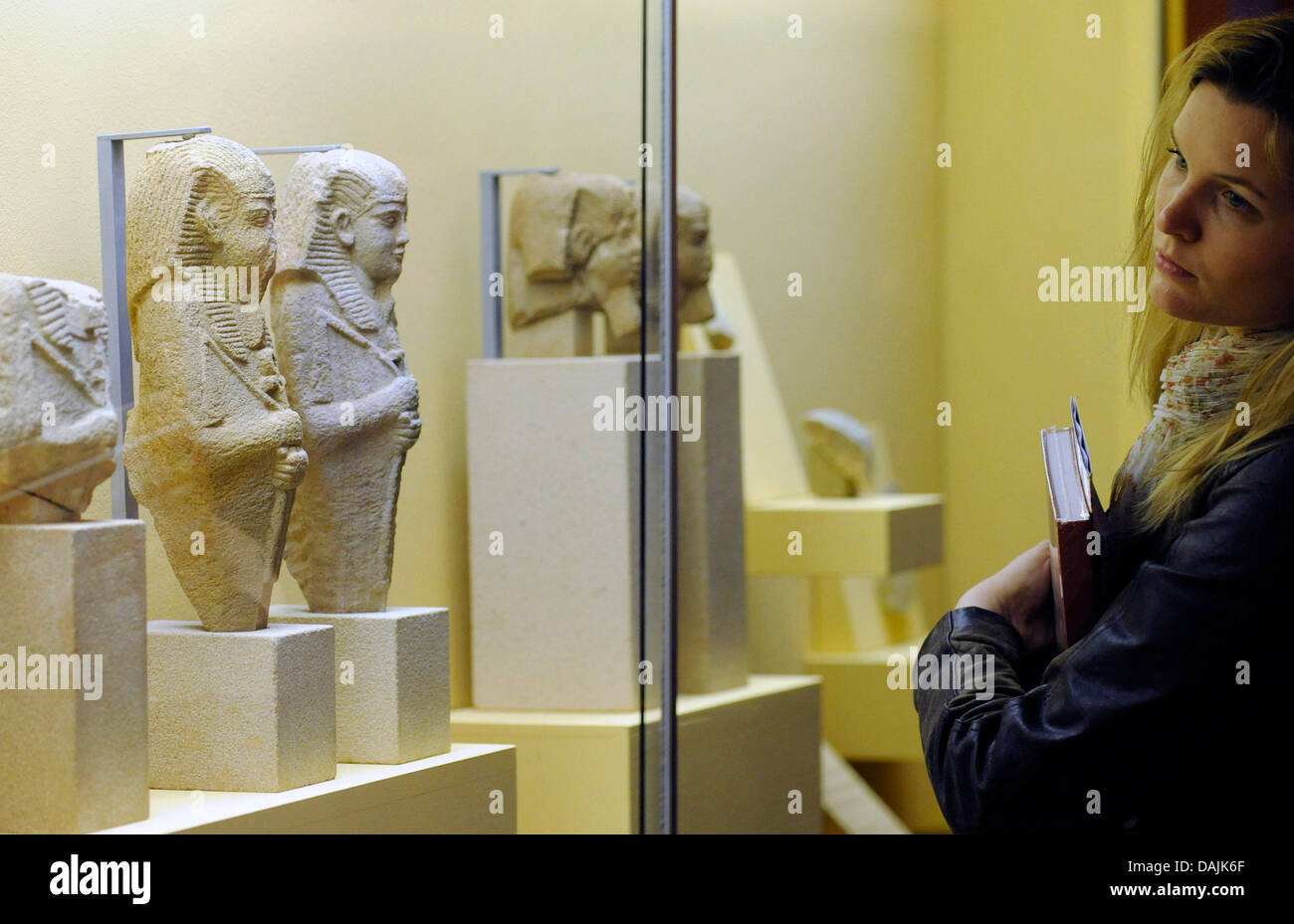 A woman looks at excavated statues at the 'King's town Naga' exhibition ...