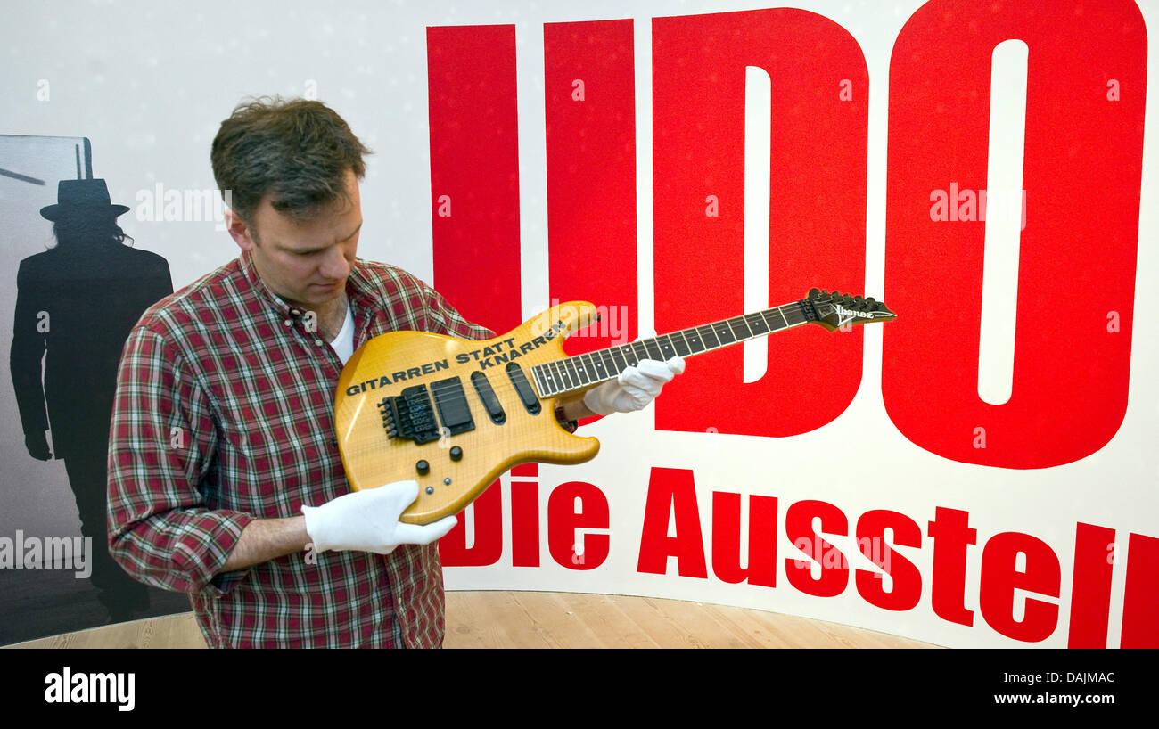 Exhibition designer John Moeller holds a guitar with the caption ...
