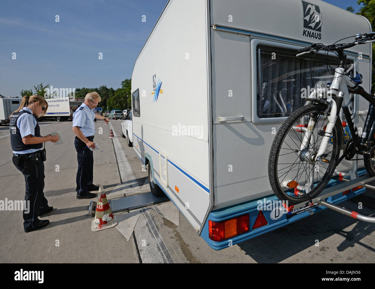 Two police officers check the weight of a travel van at autobahn A5 ...