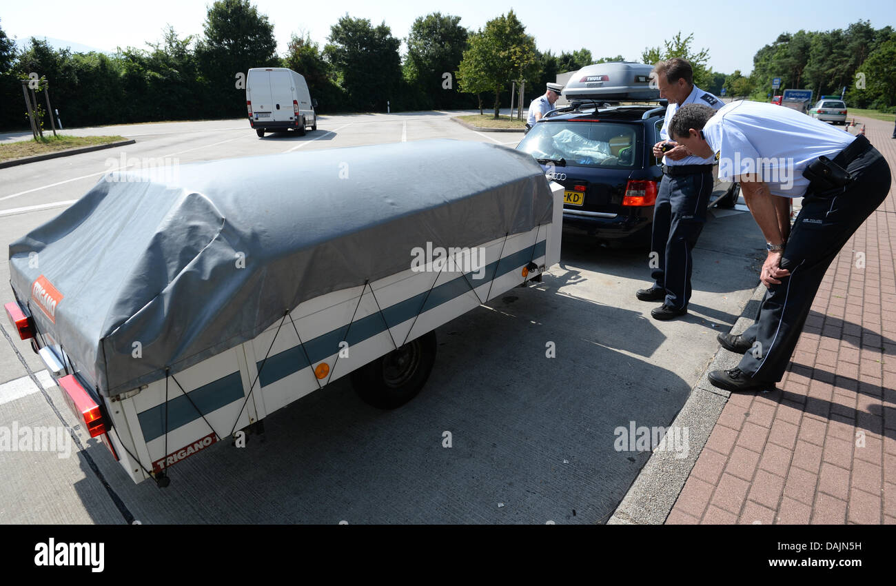 Two police officers check the weight of a caravan at autobahn A5 near ...