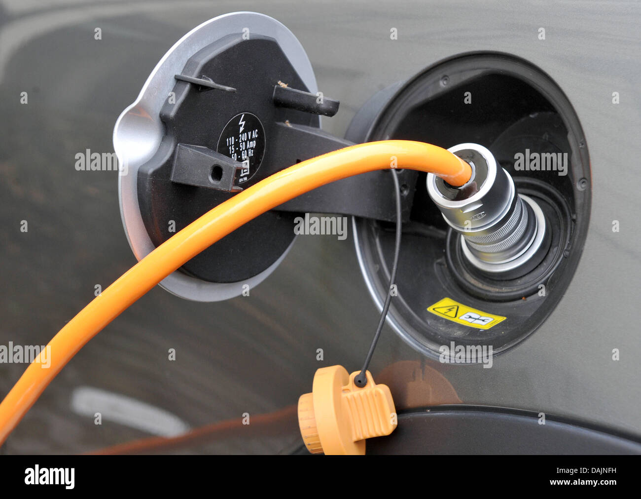 A charging cable is plugged to an open filler cap of a Mini E electric ...