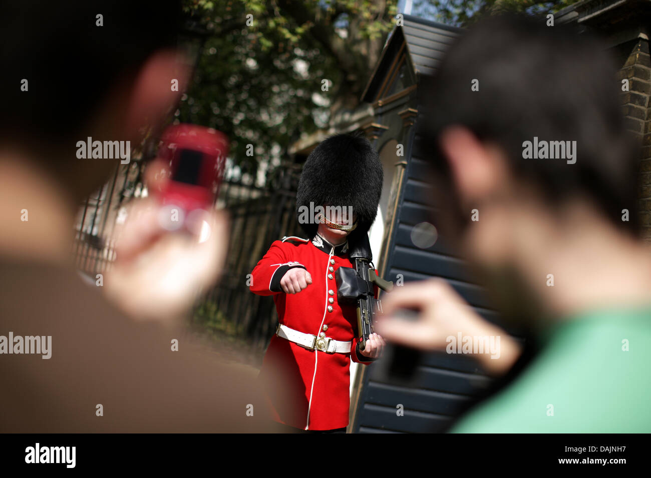 An officer of the Queen's royal guard patrols in front of Buckingham ...