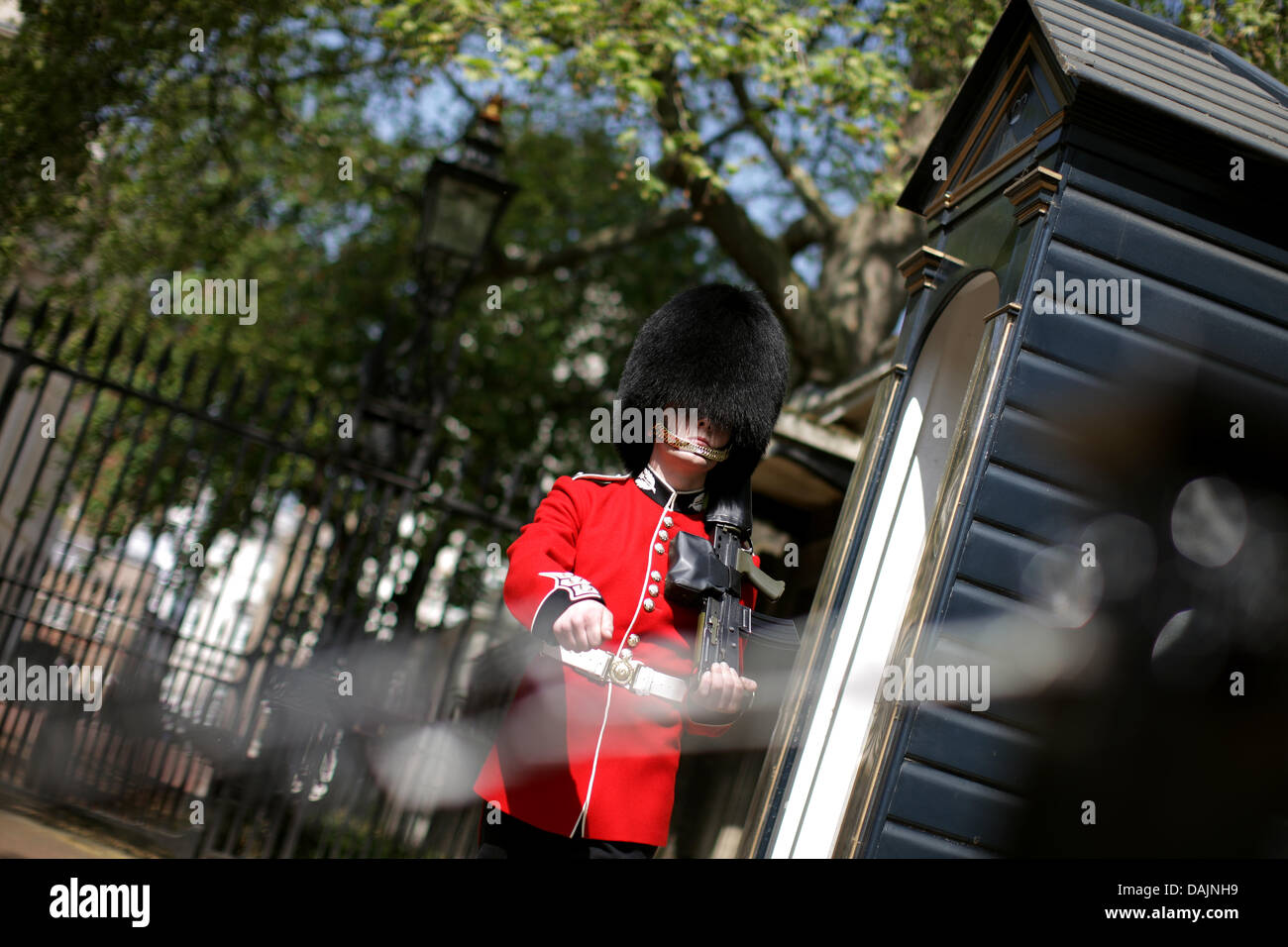 An officer of the Queen's royal guard patrols in front of Buckingham ...