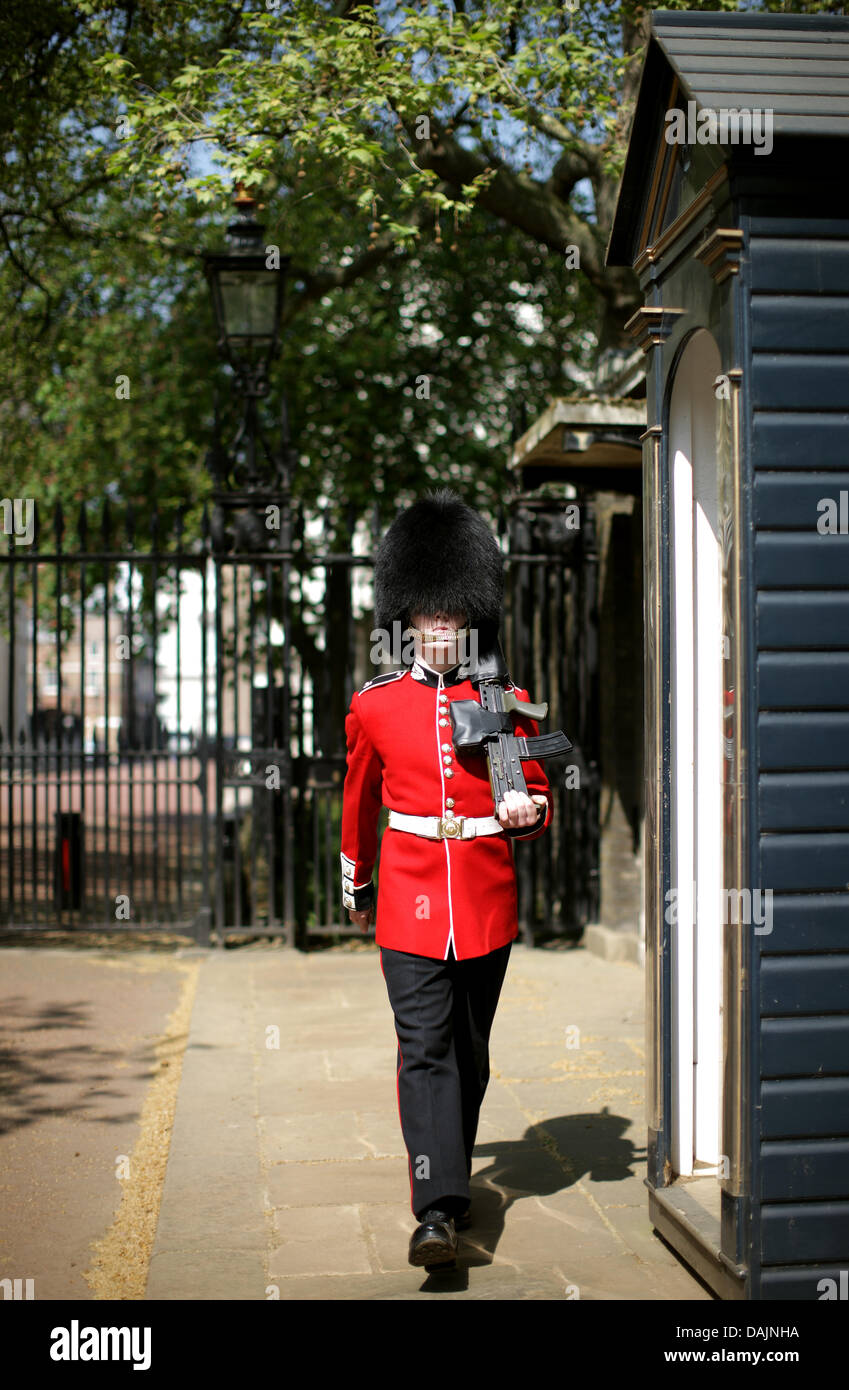 An officer of the Queen's royal guard patrols in front of Buckingham ...