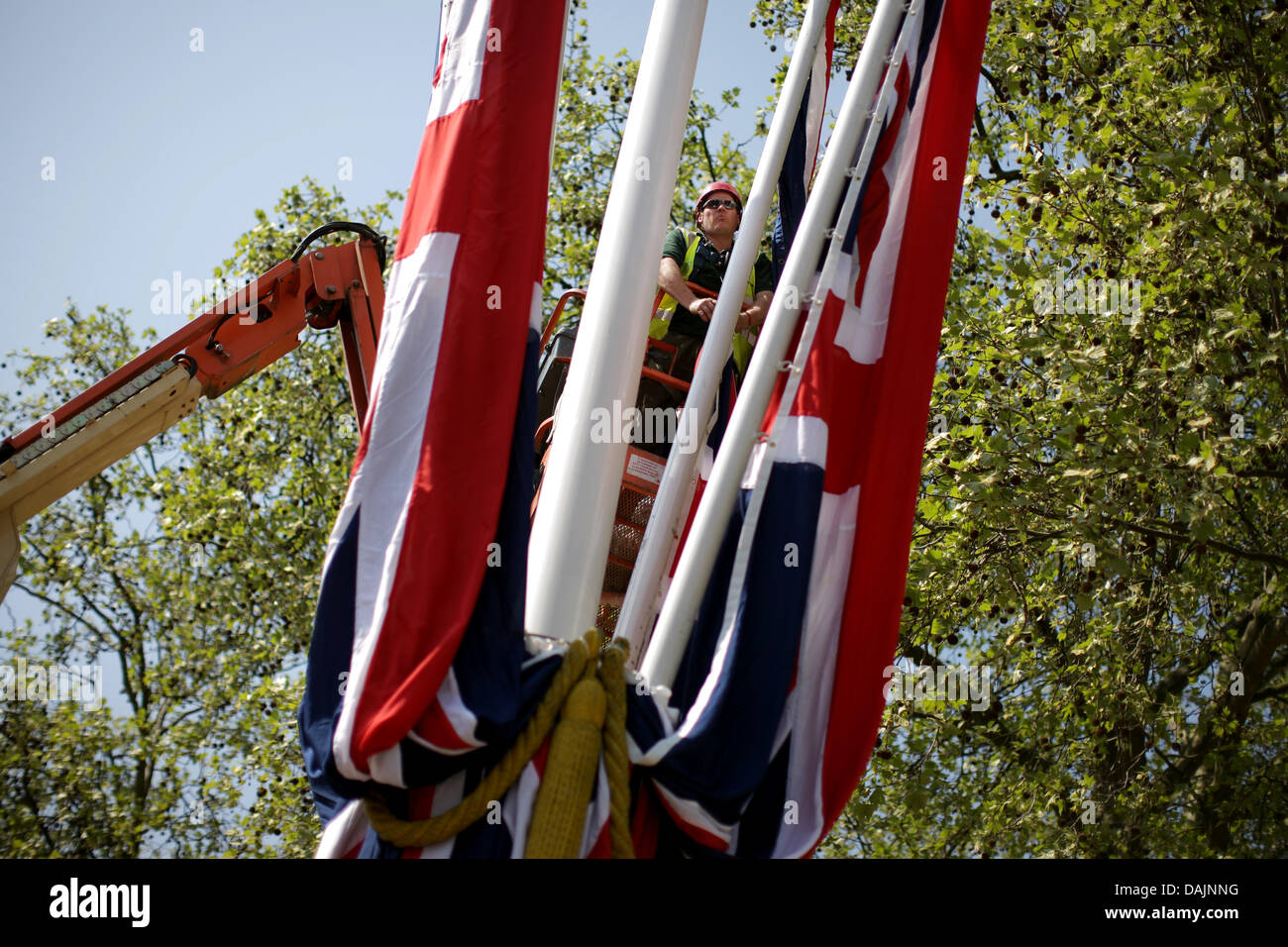 British Union Jacks are being hoisted to a pole in front of Buckingham ...