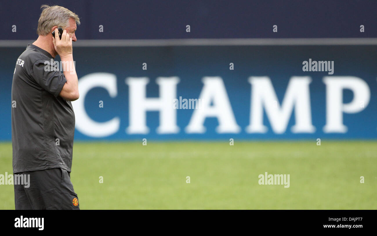 Sir Alex Ferguson, coach of Manchester United, speaks on the phone ...