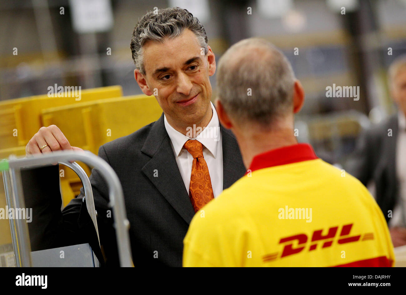 Deutsche Post and DHL CEO Frank Appel talks to an employee at the mail distribution center in ...