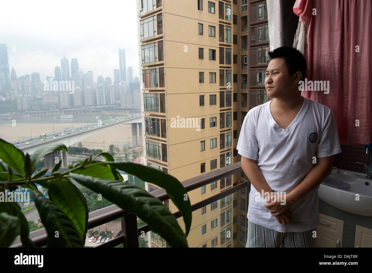 Chen Chao, 26 year old, overlooks Chongqing from the balcony of his new ...