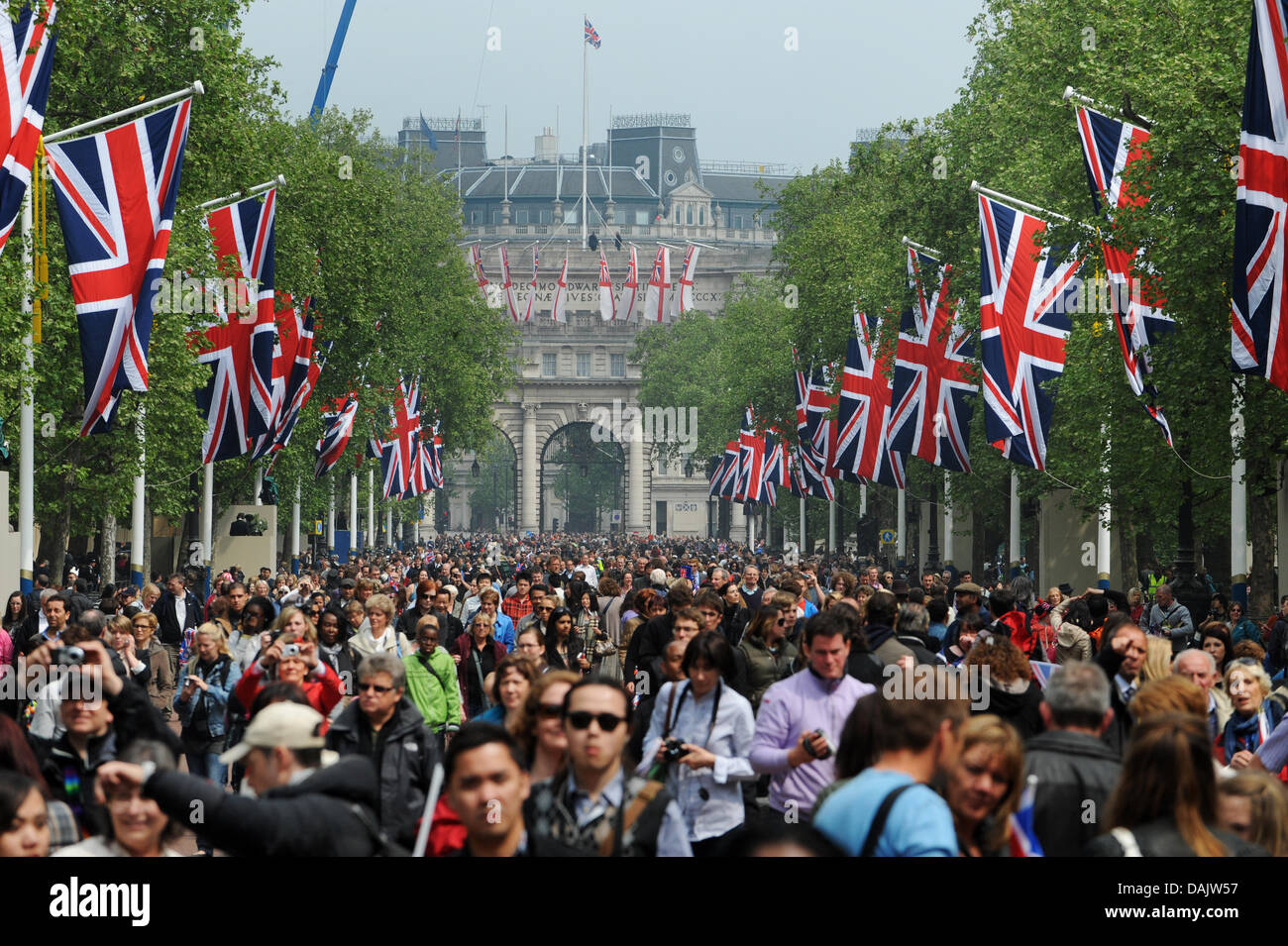Well-wishers follow the carriage procession after the wedding ceremony ...