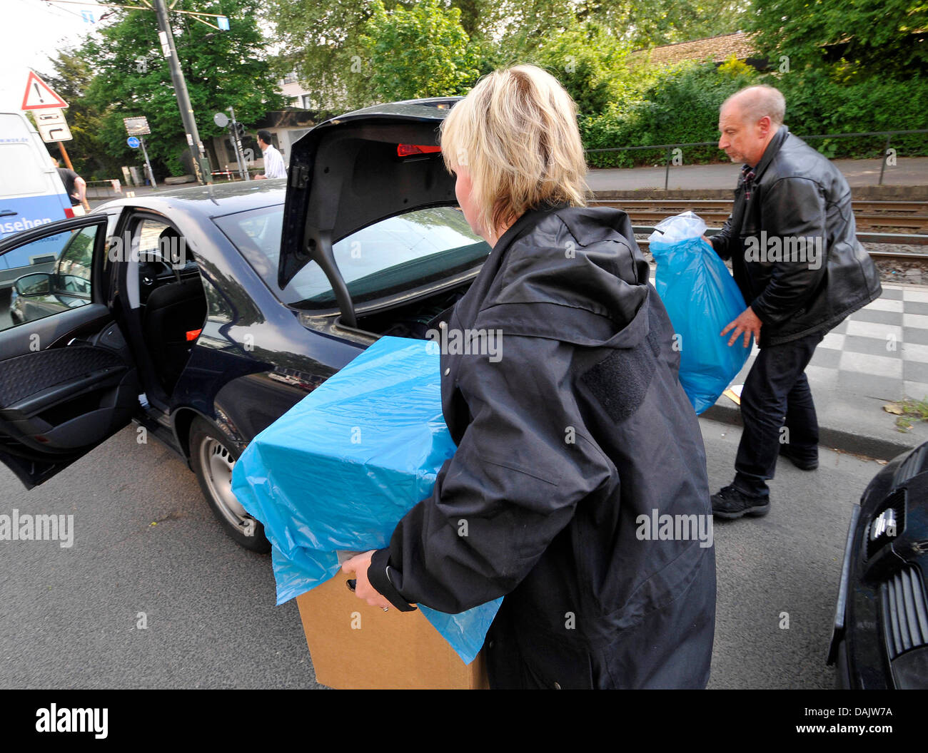 Police officers carry boxes out of a house of an alleged terrorist of ...