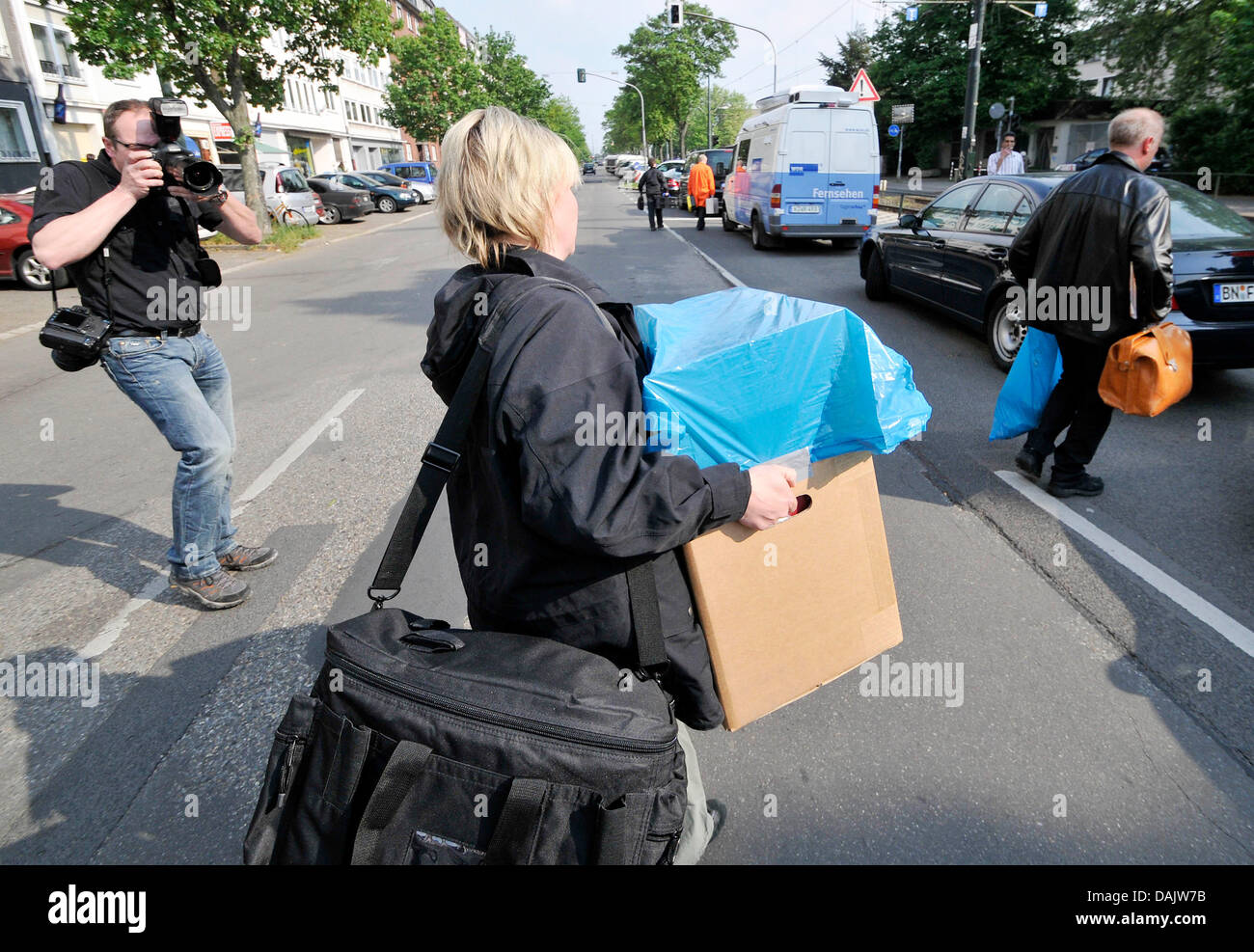 Police officers carry boxes out of a house of an alleged terrorist of ...