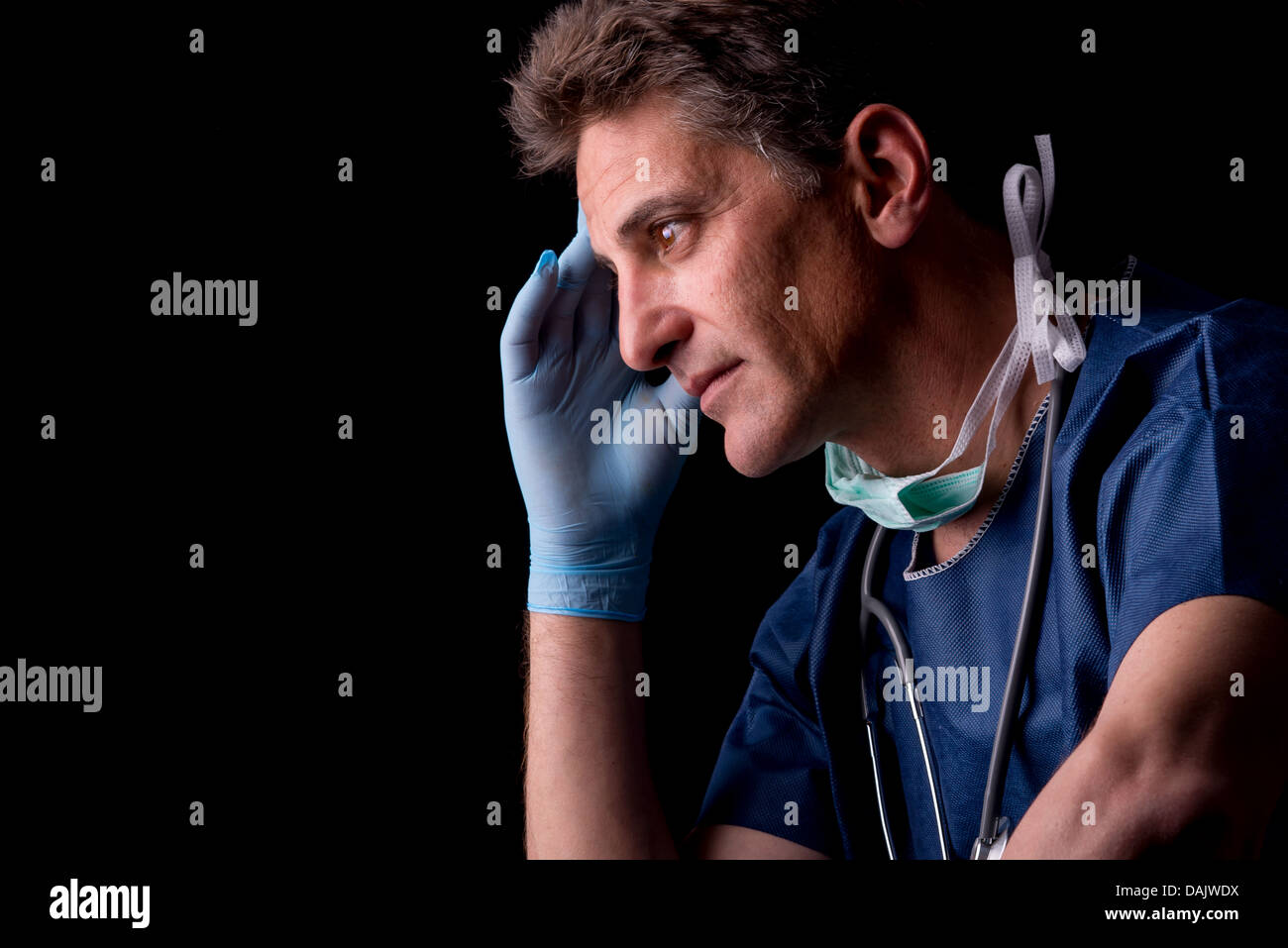 Tired doctor in uniform isolated against a black background Stock Photo ...