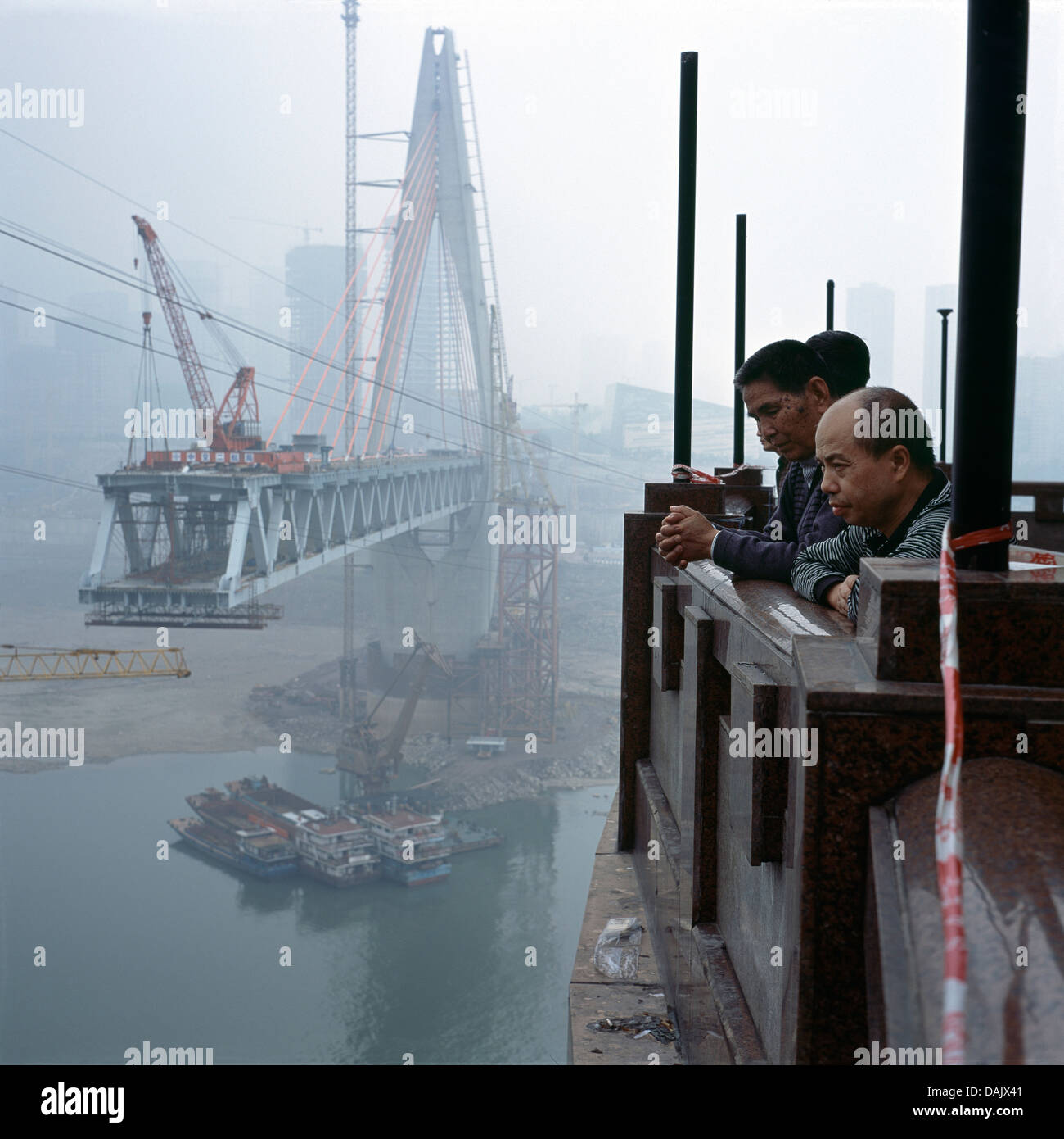 People look at the Qiansimen Bridge under construction over the Jialing ...