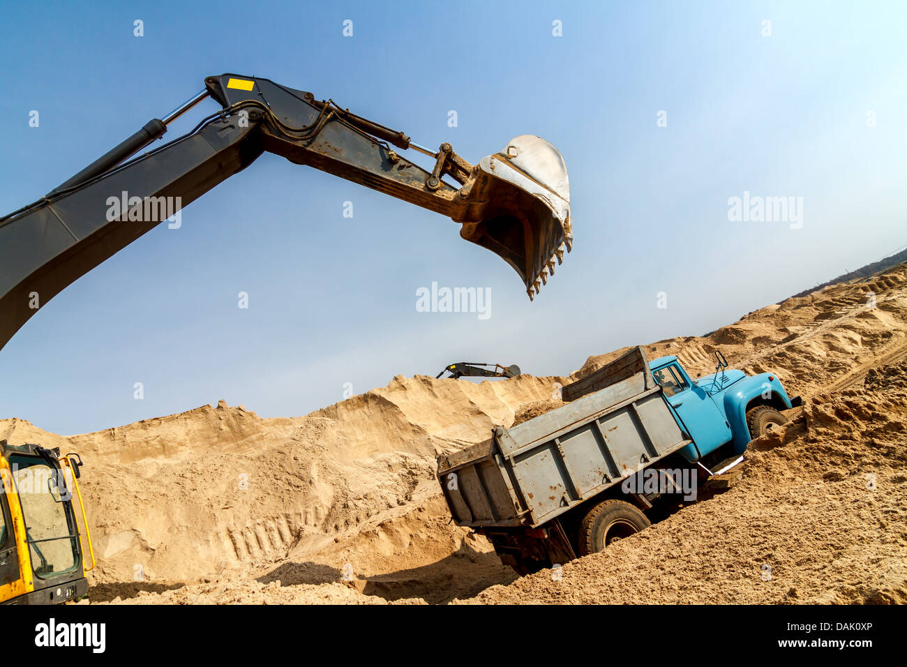 Excavator Loading Dumper Truck at Construction Site Stock Photo - Alamy