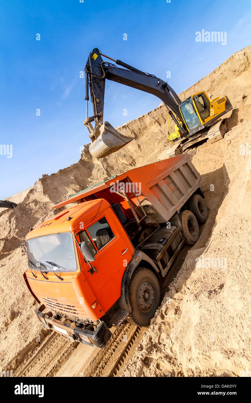 Excavator Loading Dumper Truck at Construction Site Stock Photo - Alamy