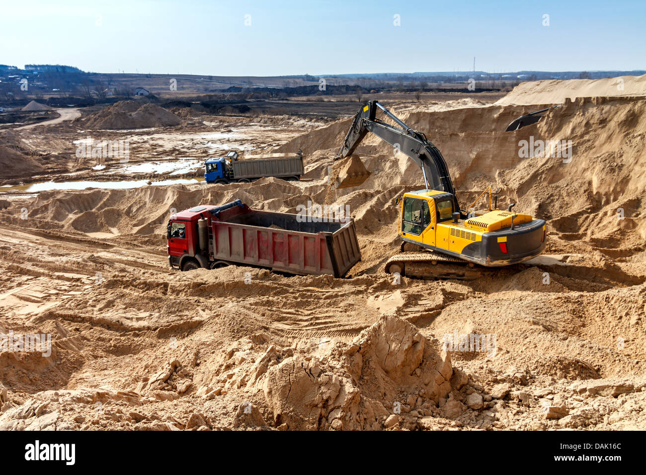 Excavator Loading Dumper Truck at Construction Site Stock Photo - Alamy