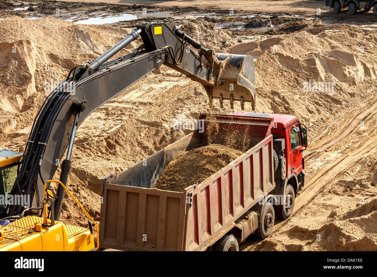 Excavator Loading Dumper Truck at Construction Site Stock Photo - Alamy