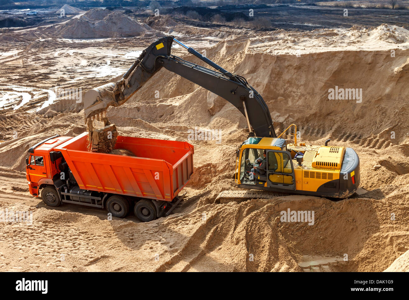 Excavator Loading Dumper Truck at Construction Site Stock Photo - Alamy