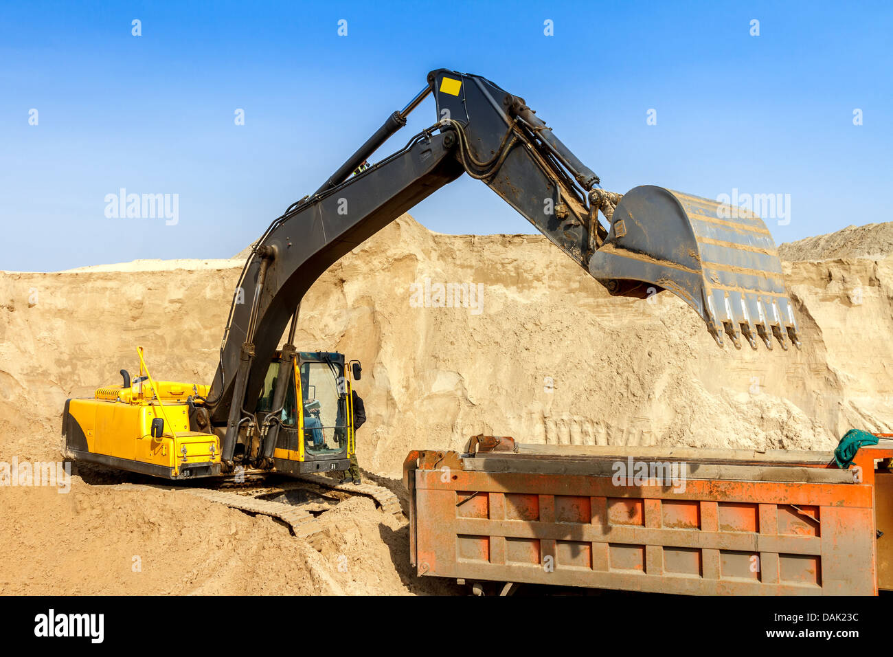Excavator Loading Dumper Truck at Construction Site Stock Photo - Alamy