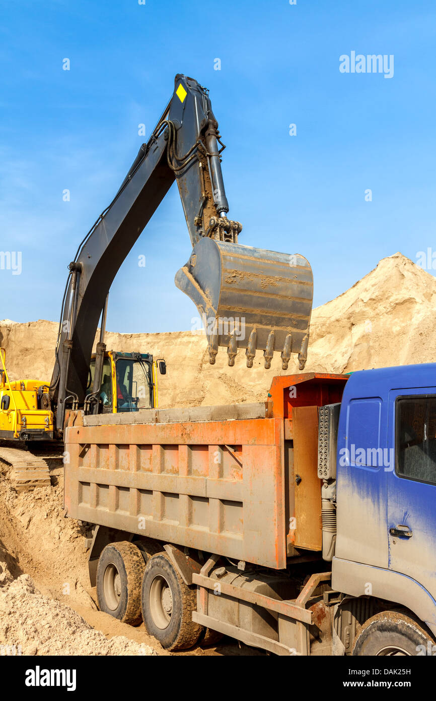Excavator Loading Dumper Truck at Construction Site Stock Photo - Alamy