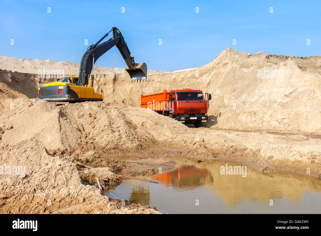Excavator Loading Dumper Truck at Construction Site Stock Photo - Alamy