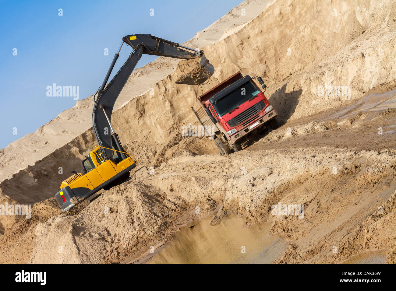 Excavator Loading Dumper Truck at Construction Site Stock Photo - Alamy