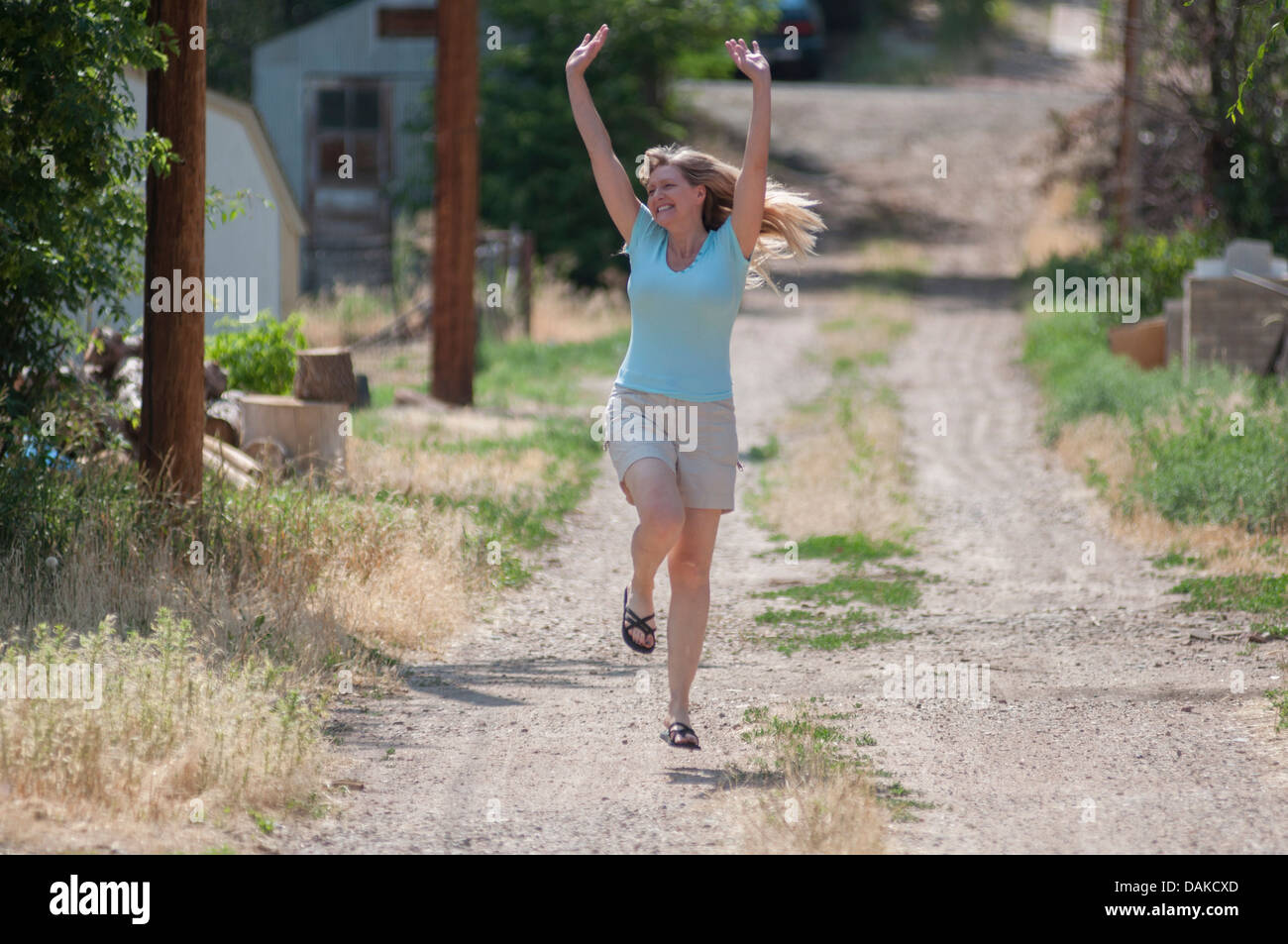 Woman skipping with arms to the sky Stock Photo - Alamy