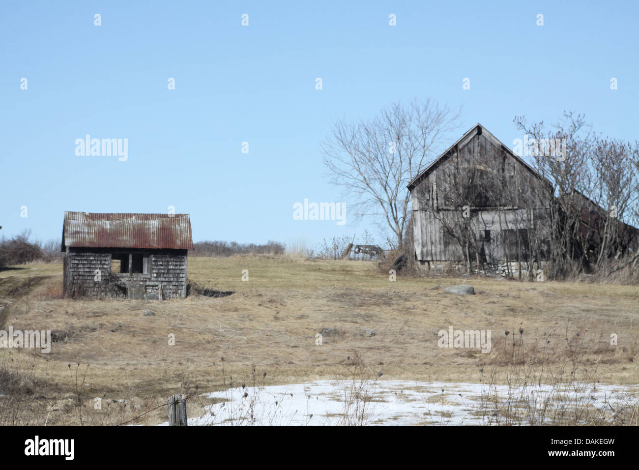 Old, abandoned, dilapidated, farm building on slight, foliage covered ...