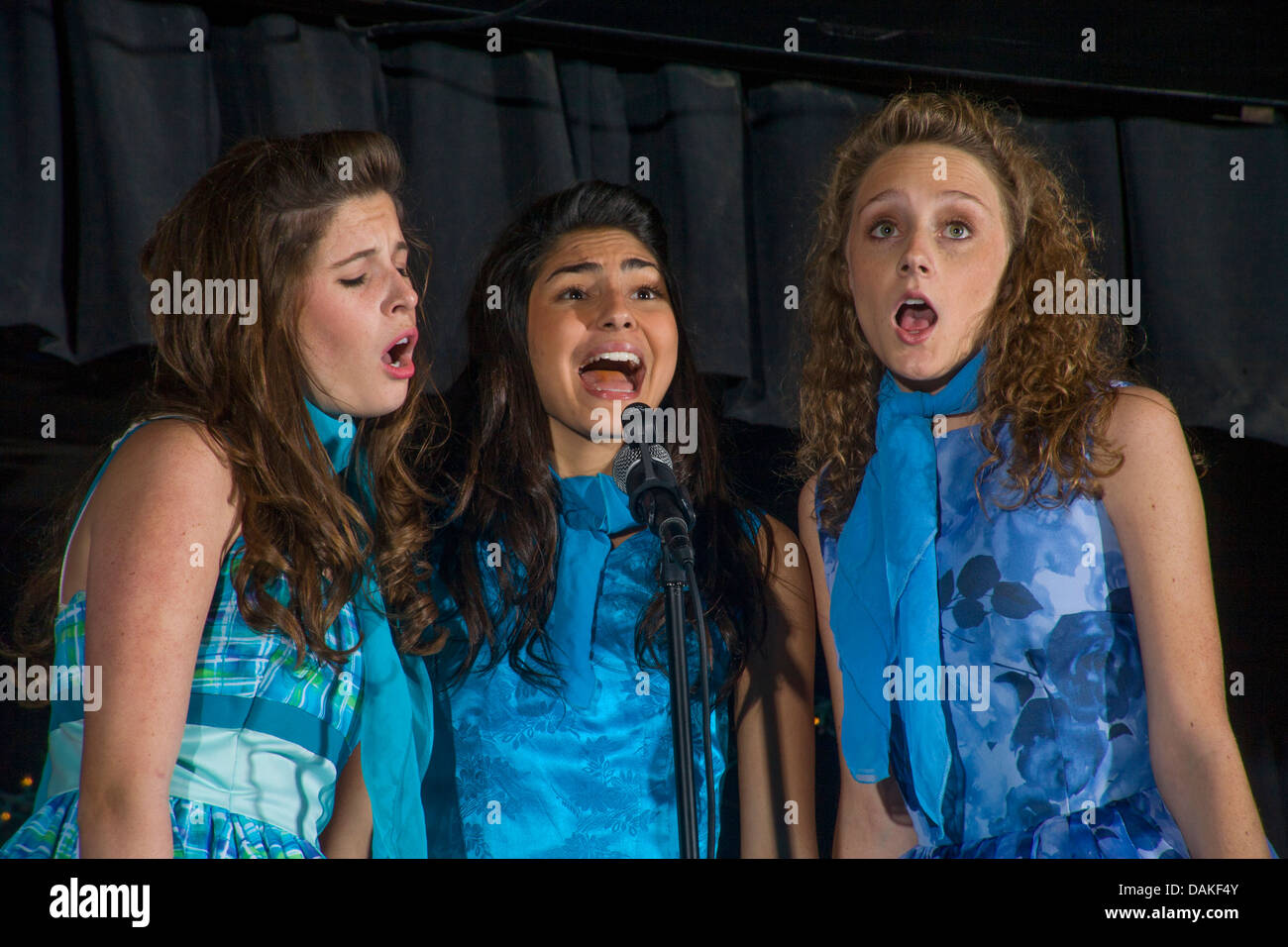 In 1950's dresses, a girls' trio sings at the Rydell High School prom ...