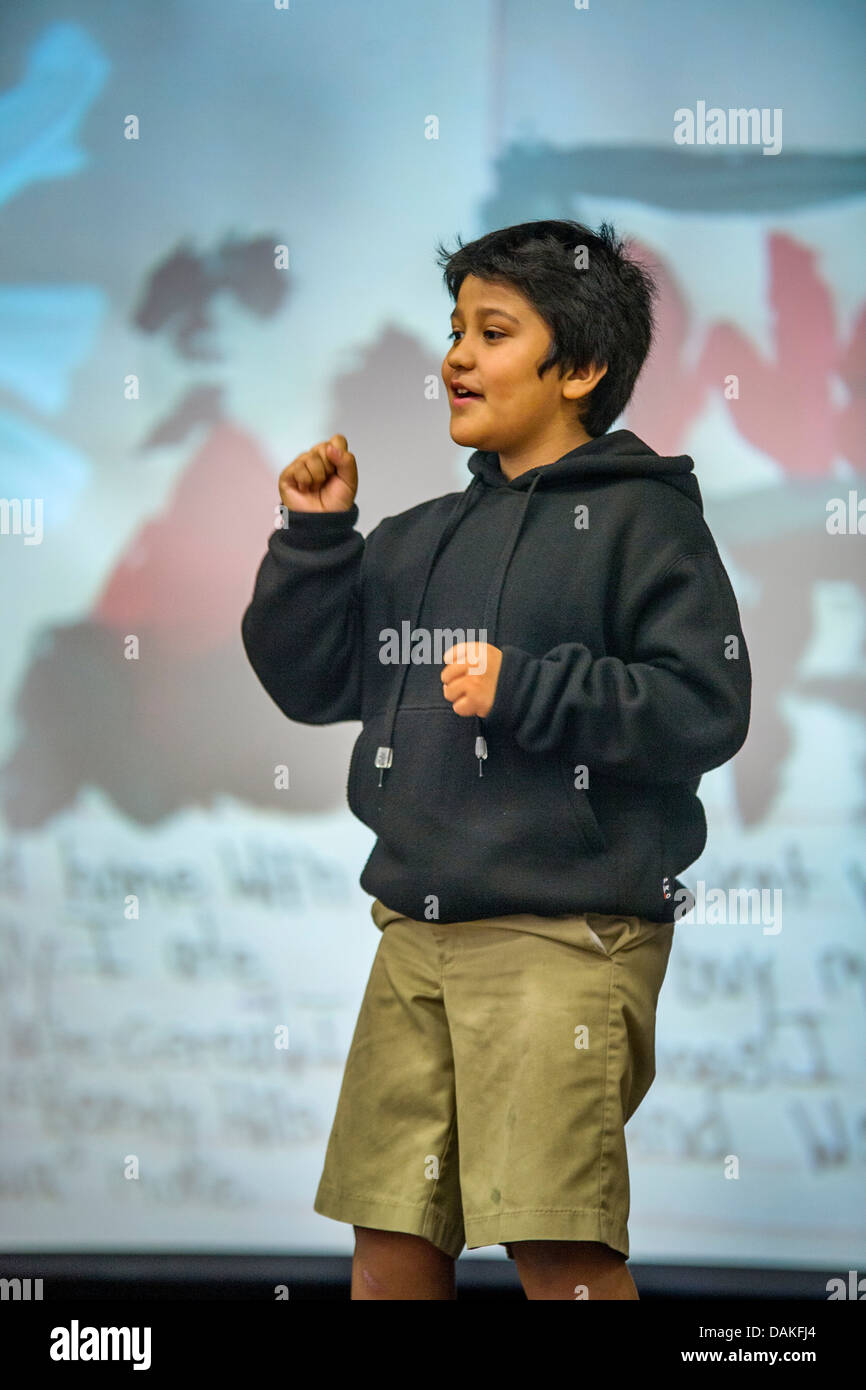 A deaf child uses sign language to "read" the composition he has ...