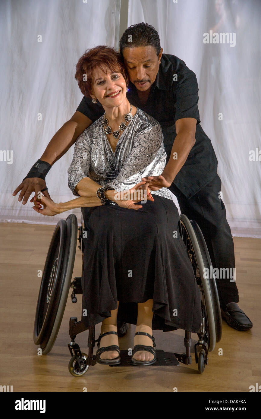 An African American dance teacher instructs handicapped adults perform ...