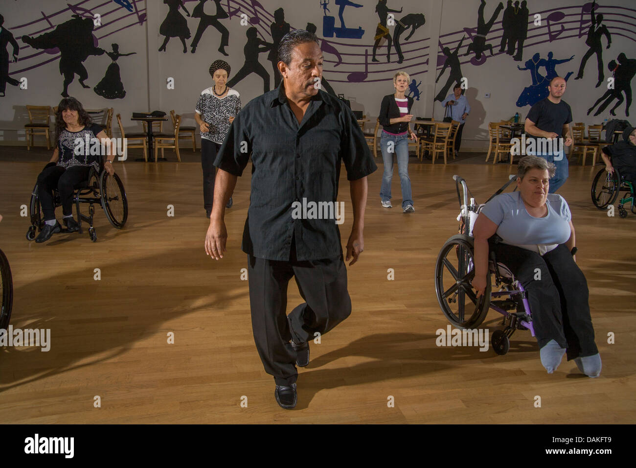 An African American dance teacher instructs handicapped adults perform ...