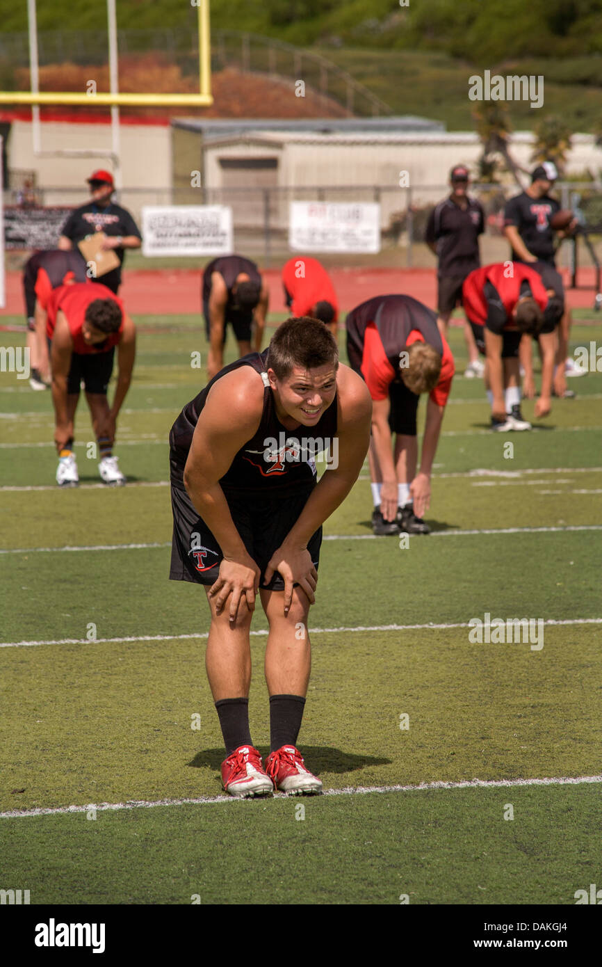 Multi-ethnic high school athletes limber up with flexibility exercises ...