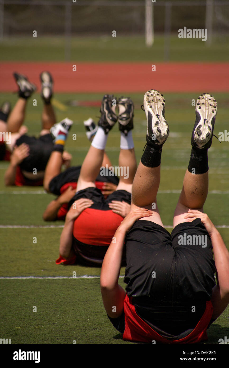 Multi-ethnic high school athletes limber up with flexibility exercises ...