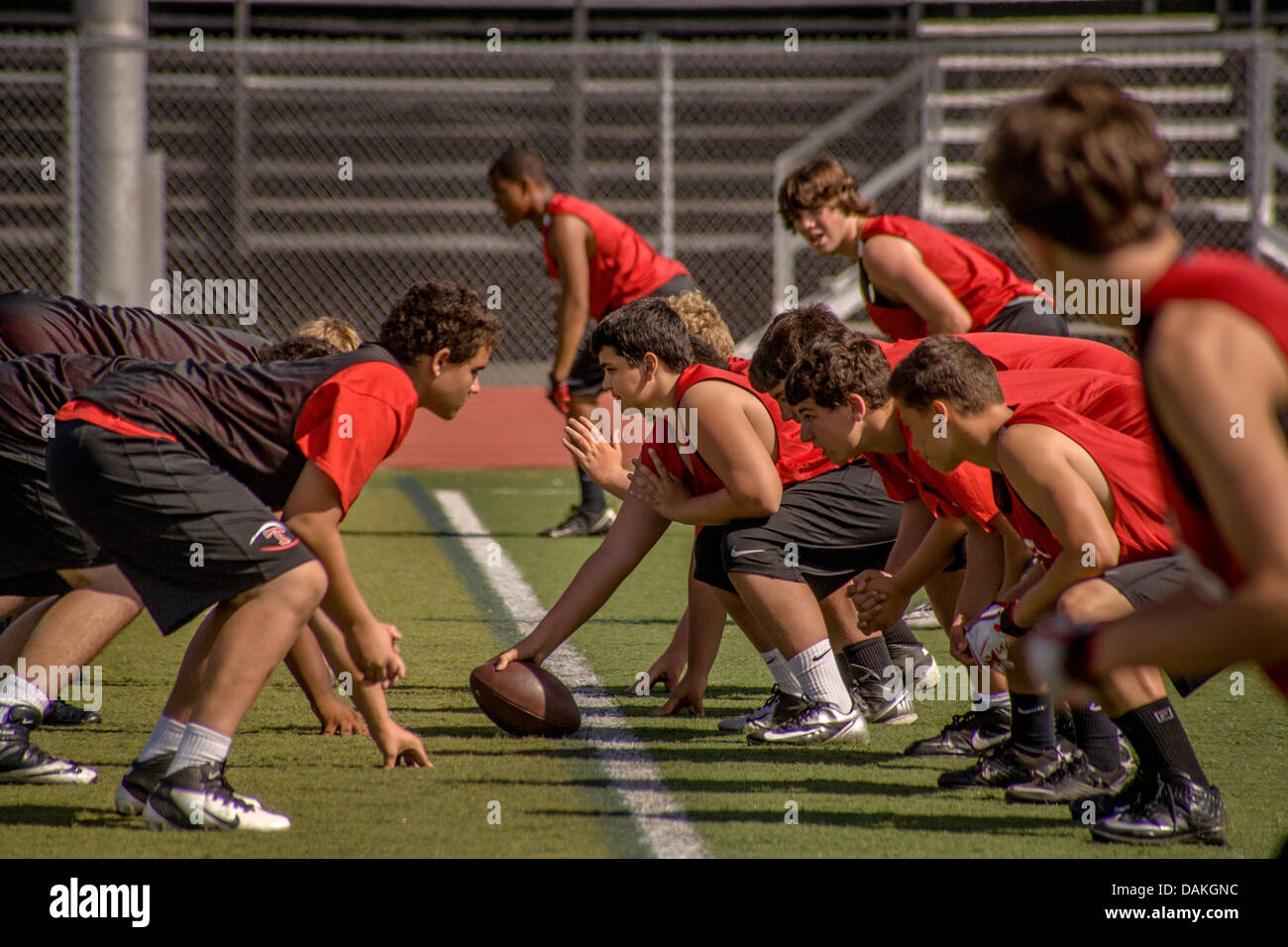 High school athletes scrimmage during spring football practice in San ...