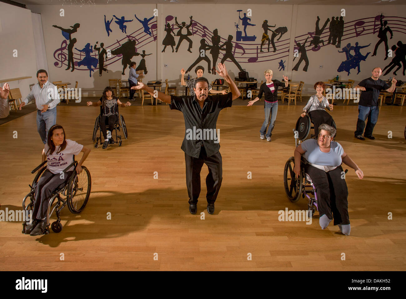 An African American dance teacher instructs handicapped adults in ...