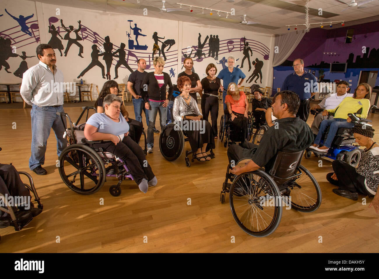 An African American dance teacher instructs handicapped adults in ...