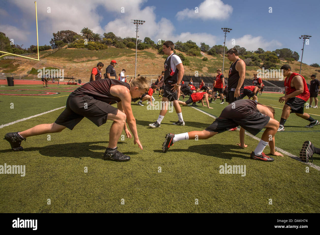 High school athletes limber up with flexibility exercises as they begin ...