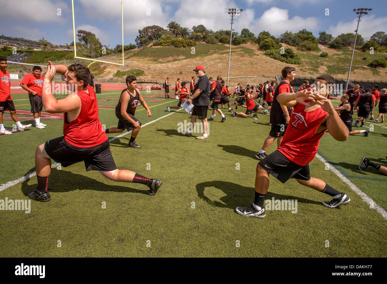 High school athletes limber up with flexibility exercises as they begin ...