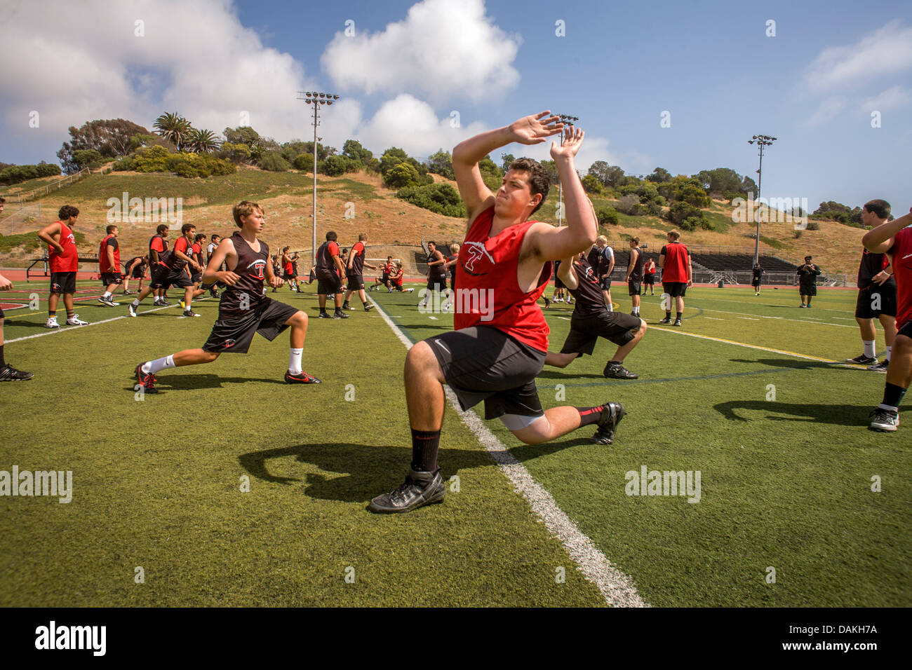 High school athletes limber up with flexibility exercises as they begin ...